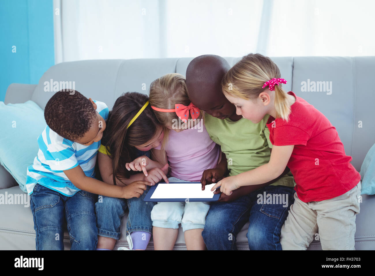 Happy kids using technology while sitting Stock Photo - Alamy