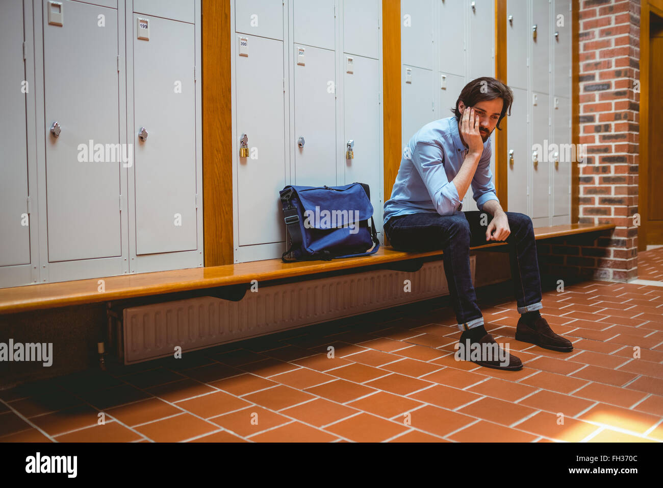 Hipster student feeling sad in hallway Stock Photo - Alamy