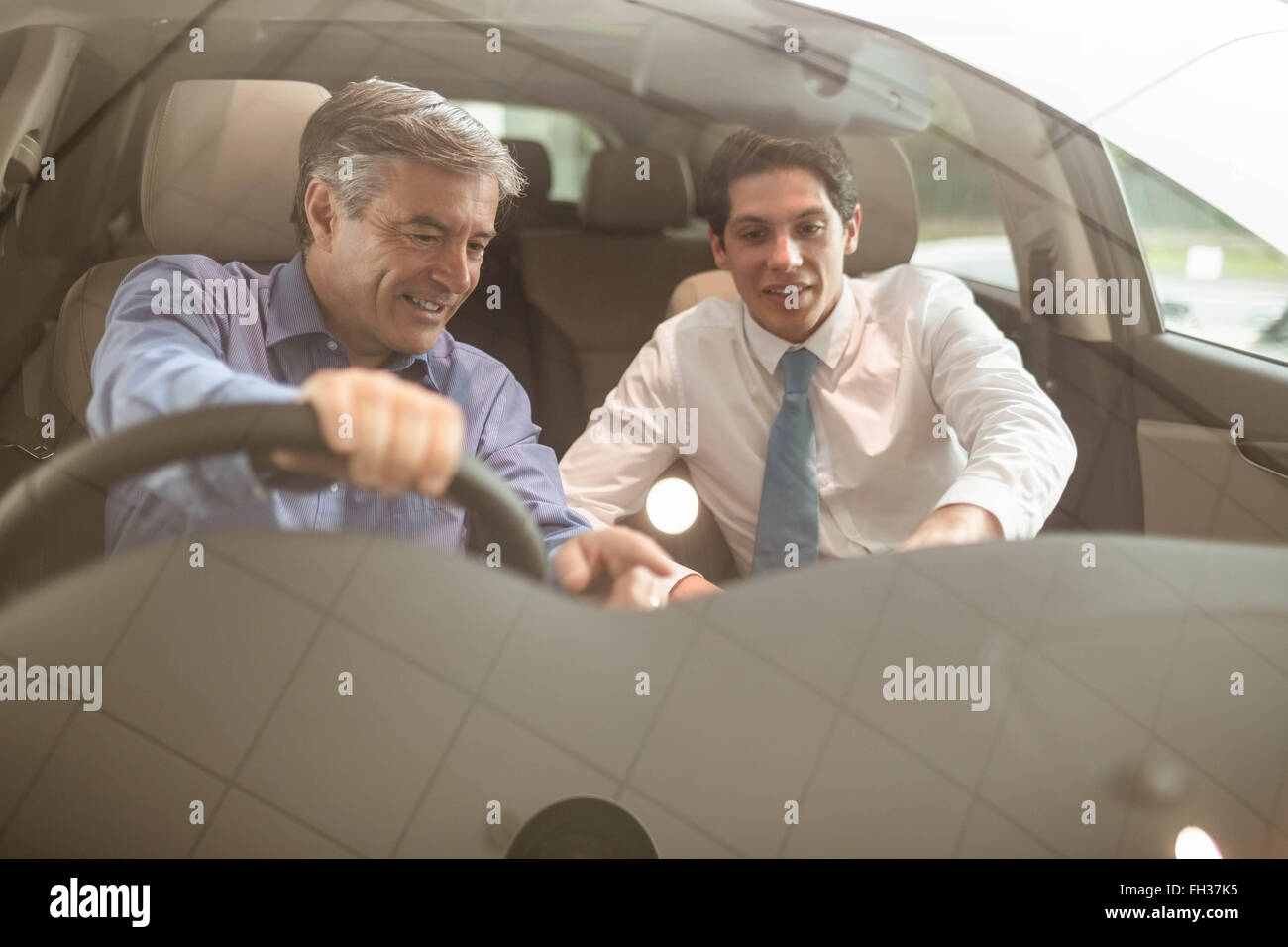 Businessman pointing a car interior Stock Photo - Alamy