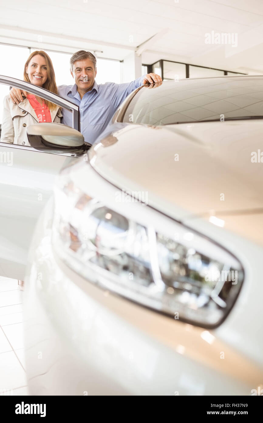 Smiling couple leaning on car Stock Photo - Alamy