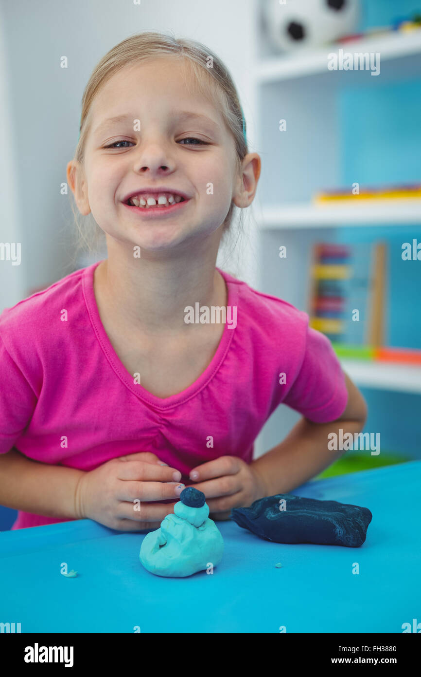 Smiling girl playing with modelling clay Stock Photo - Alamy