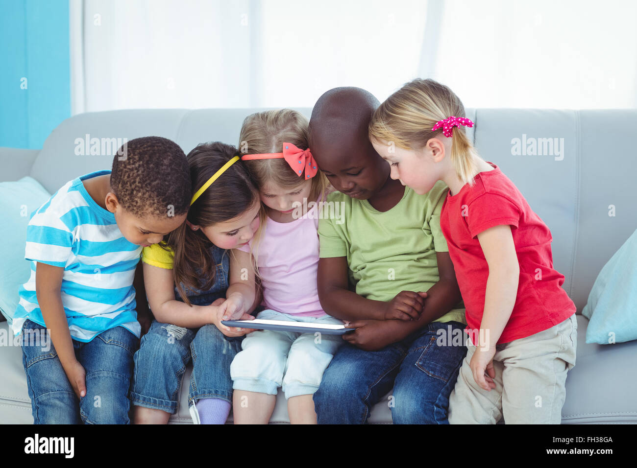 Happy kids using technology while sitting Stock Photo - Alamy