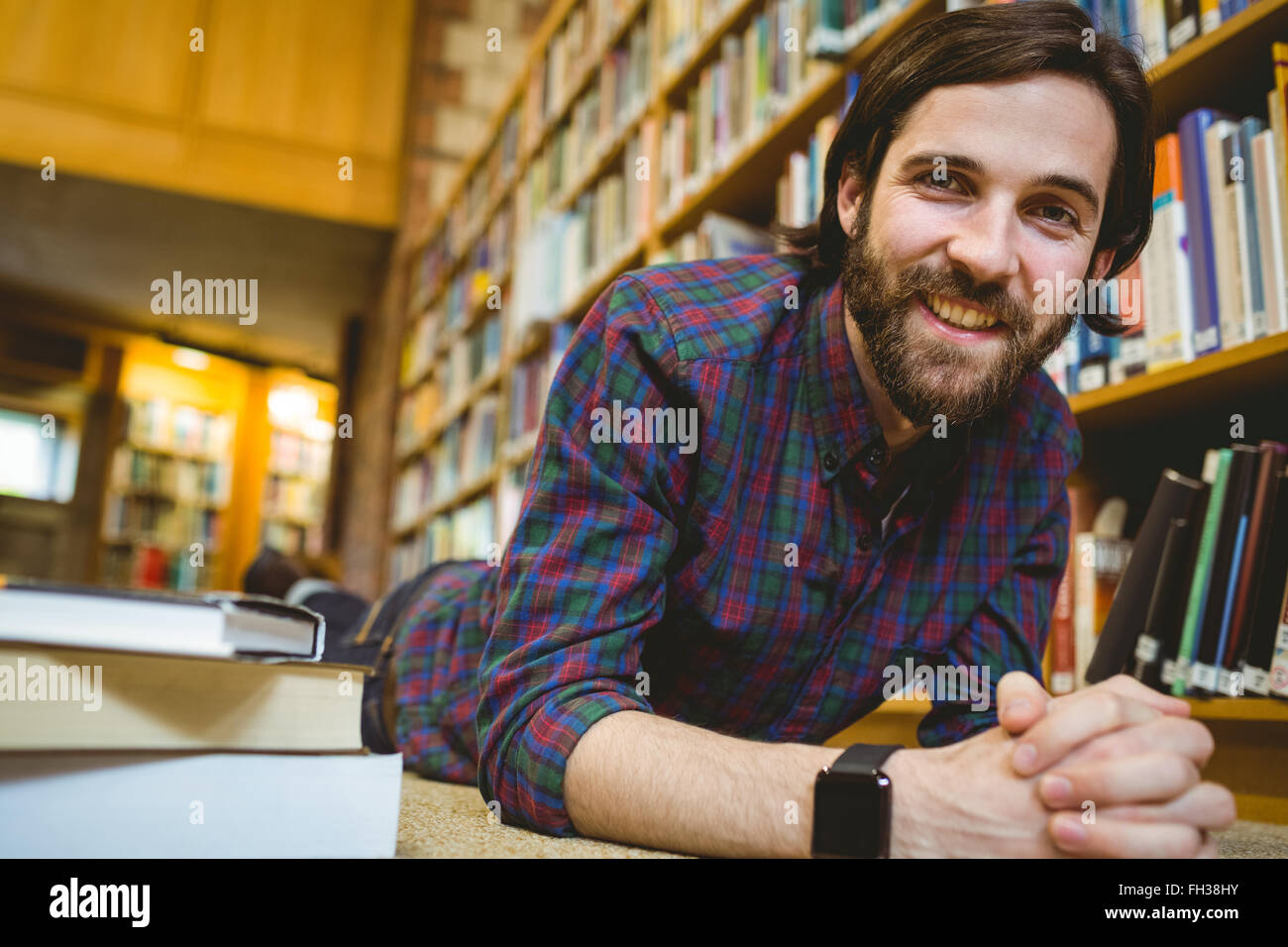 Student studying on floor in library wearing smart watch Stock Photo ...