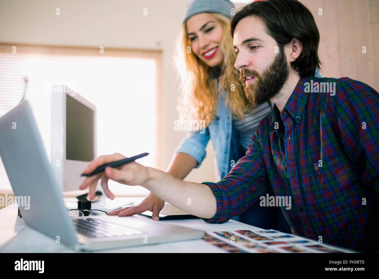 Creative team working on laptop together Stock Photo - Alamy