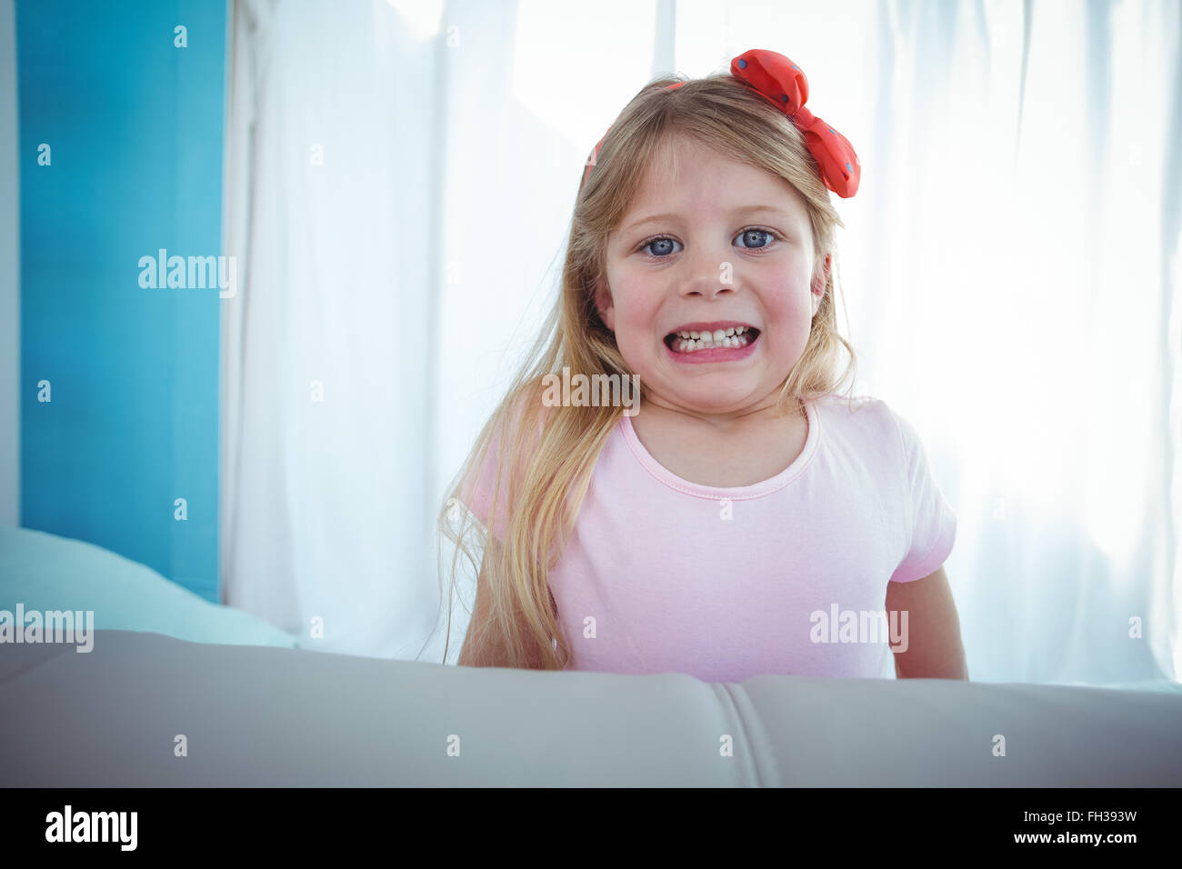Happy kids looking from the back of the couch Stock Photo - Alamy