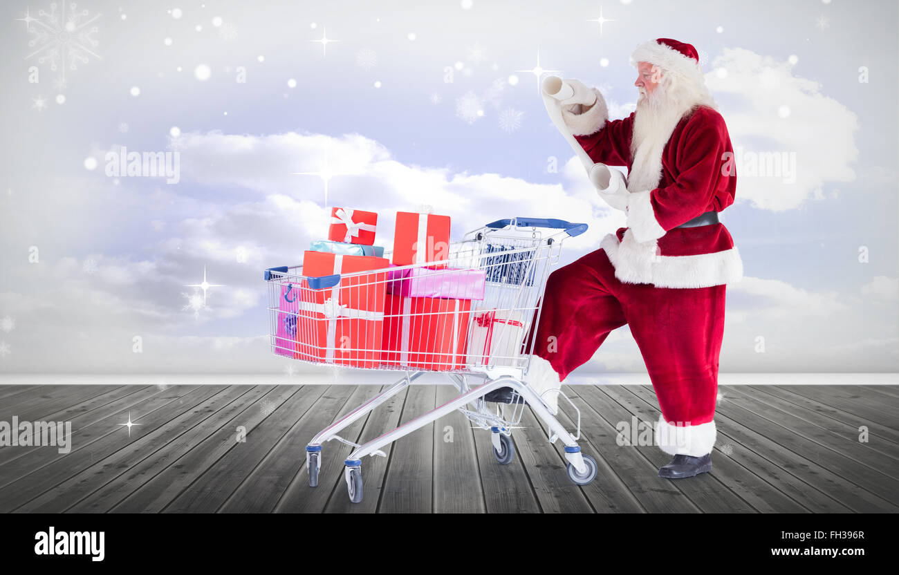 Composite image of santa delivering gifts from cart Stock Photo - Alamy
