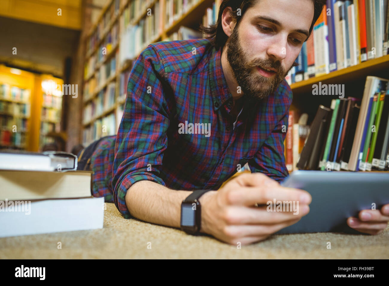 Student studying on floor in library wearing smart watch Stock Photo ...