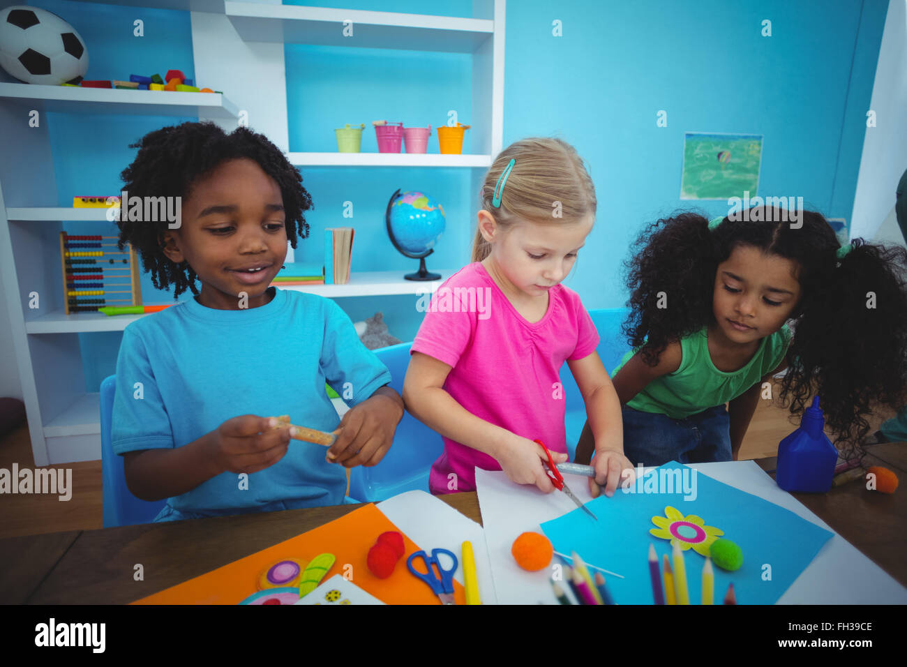 Happy kids using modelling clay together Stock Photo - Alamy