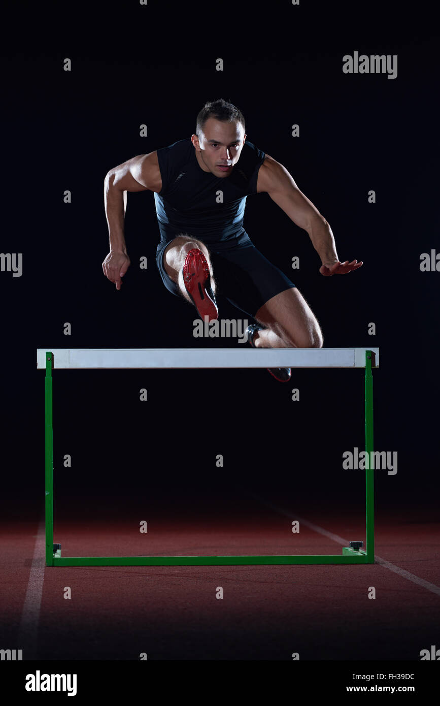 athlete jumping over a hurdles Stock Photo - Alamy