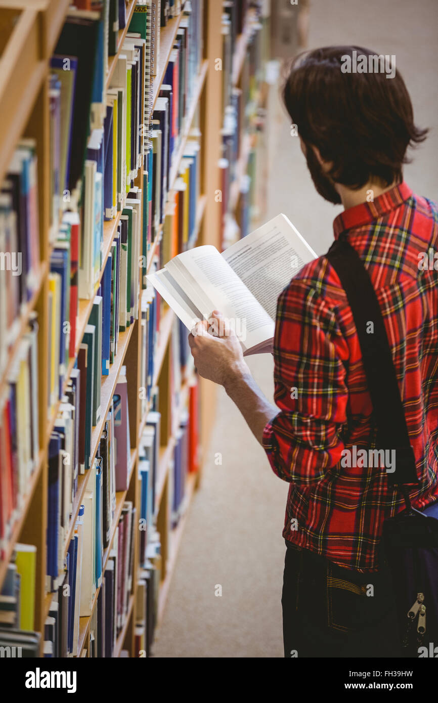 Student picking a book from shelf in library Stock Photo - Alamy