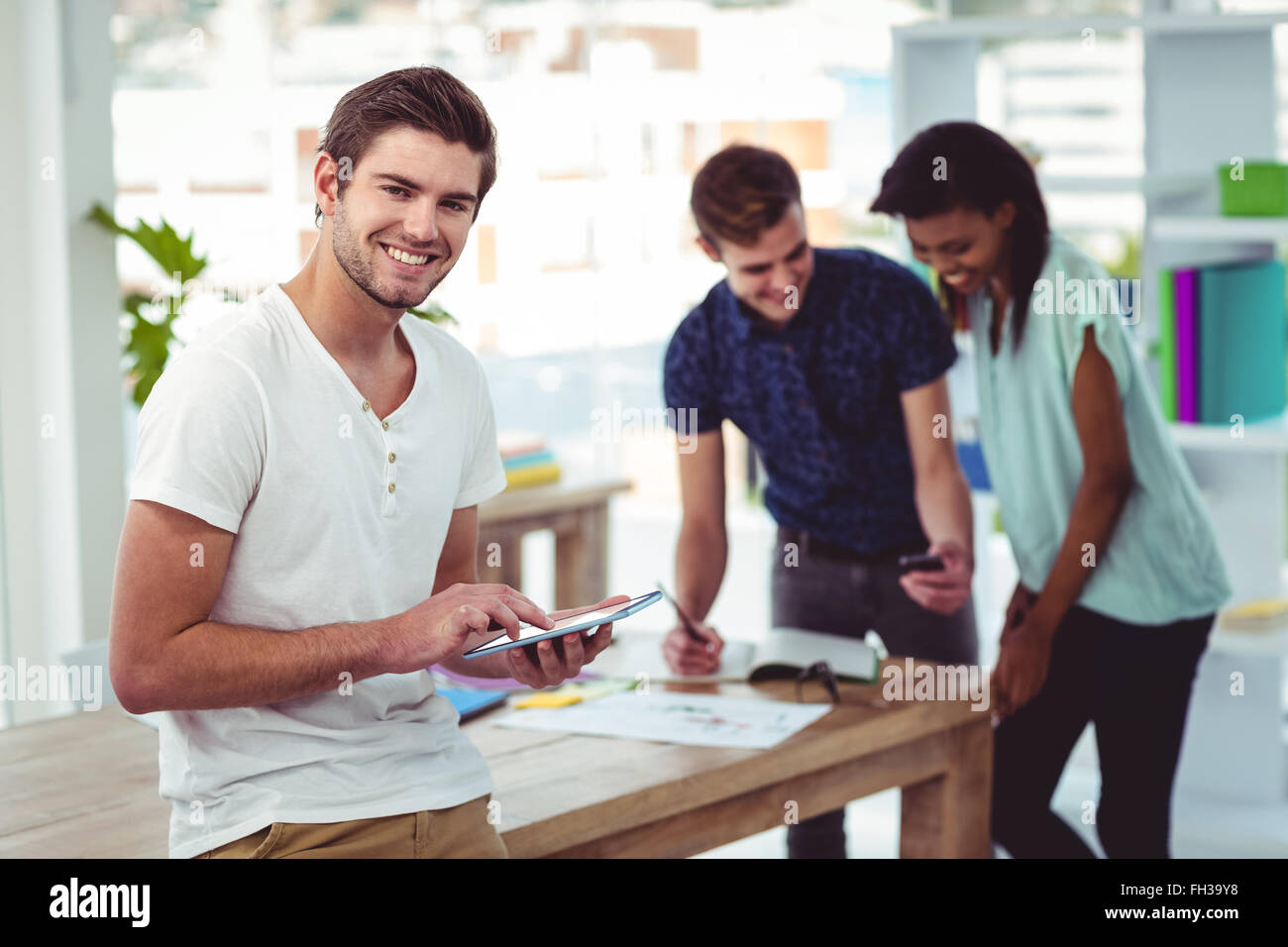 Smiling creative team working together Stock Photo - Alamy