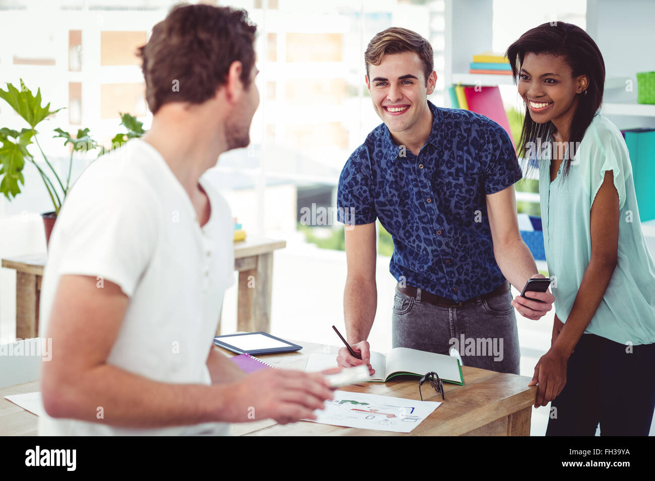 Smiling creative team working together Stock Photo - Alamy