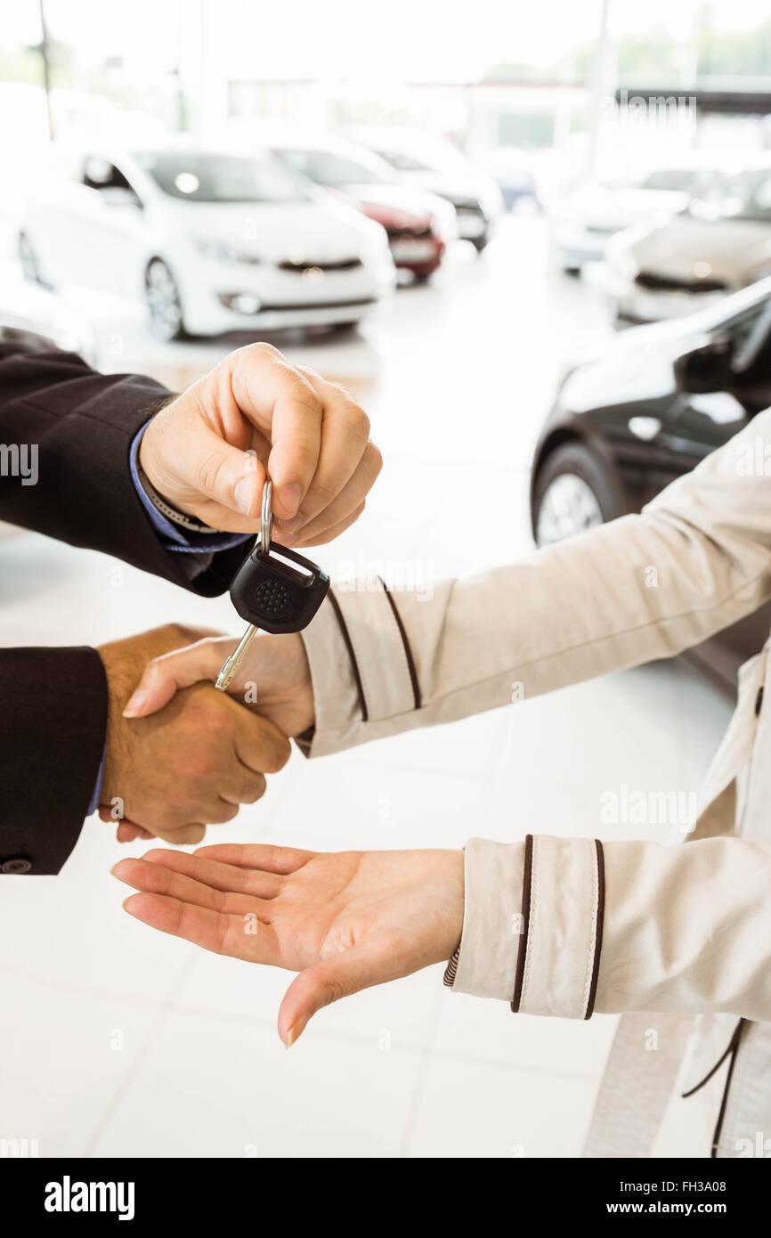 Salesman offering car key to a customers Stock Photo - Alamy