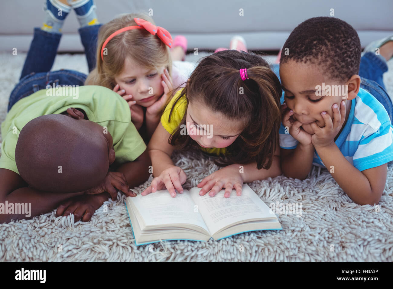 Happy kids reading a book together Stock Photo - Alamy