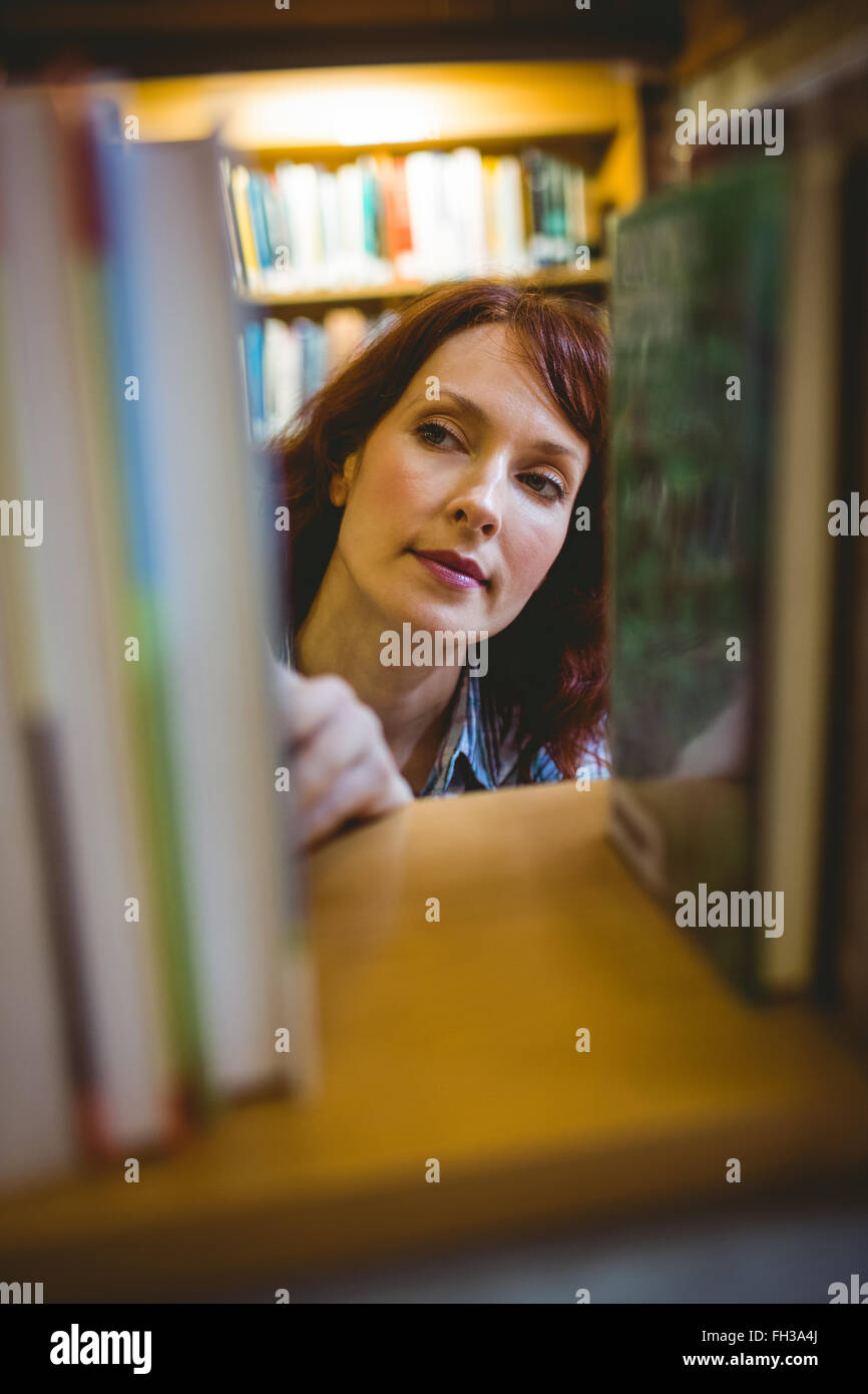 Mature student picking out book in library Stock Photo - Alamy