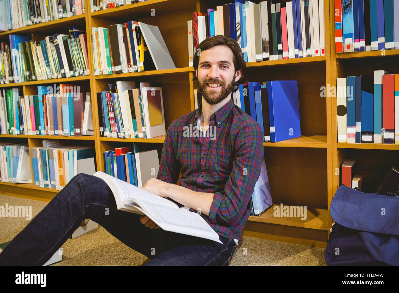 Student reading book in library on floor Stock Photo - Alamy