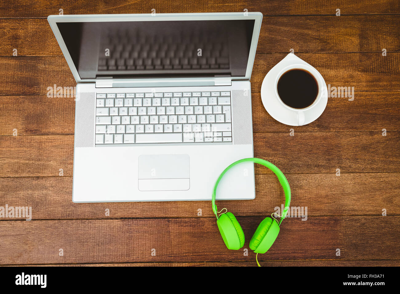 View of a grey laptop with a green headphone Stock Photo - Alamy