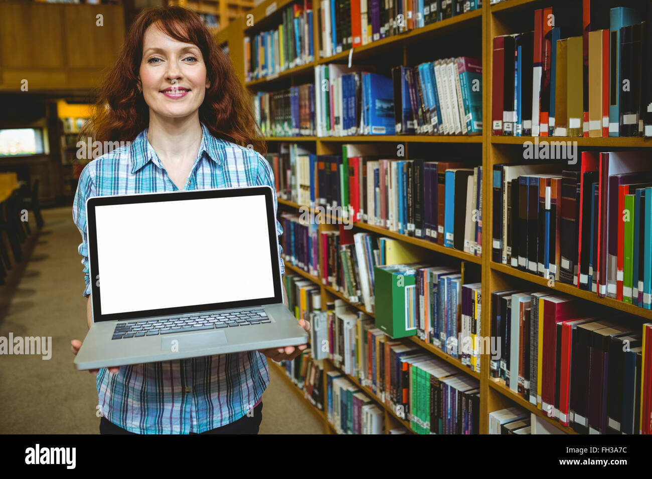 Mature student in library using laptop Stock Photo - Alamy