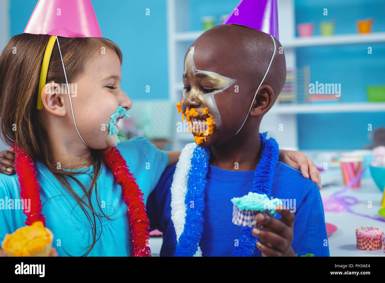 Smiling kids with icing on their faces Stock Photo - Alamy