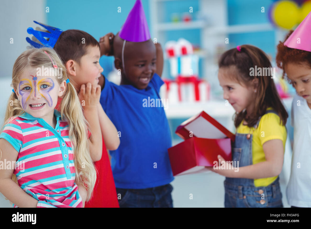 Happy girl opening a present Stock Photo - Alamy