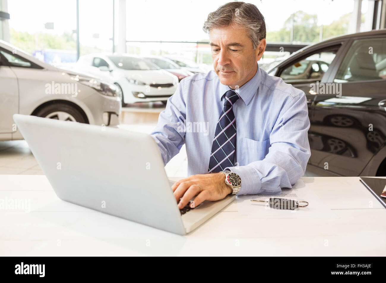 Serious salesman behind his desk Stock Photo - Alamy