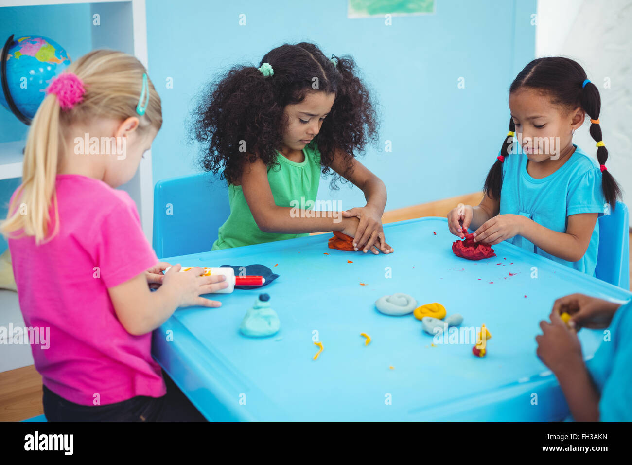 Smiling girls playing with modelling clay Stock Photo - Alamy