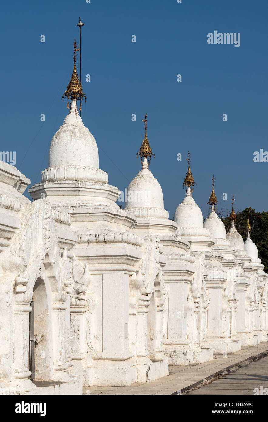 Row of whitewashed stone-inscription caves at Kuthodaw Pagoda in ...