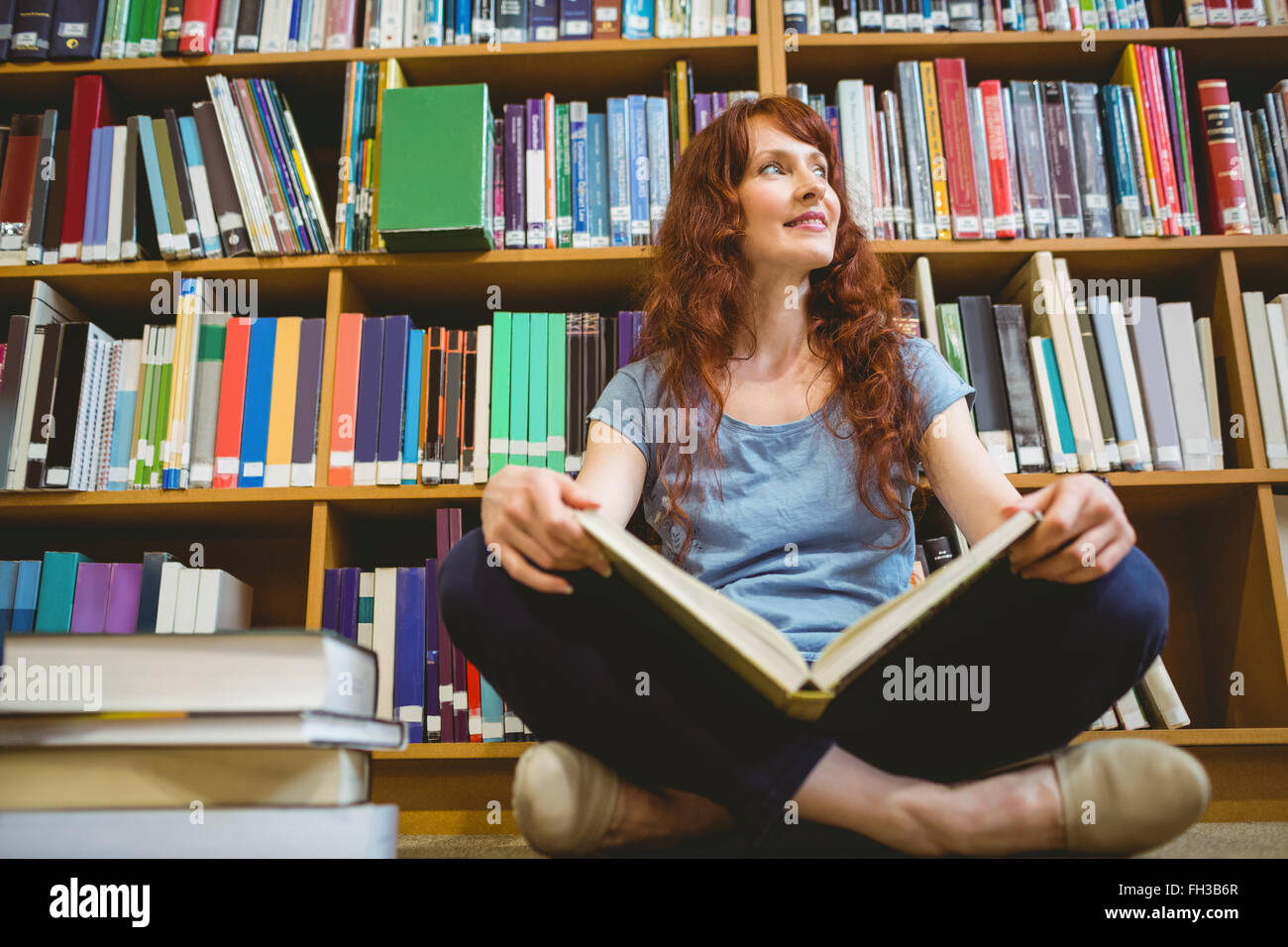 Mature student reading book in library Stock Photo - Alamy