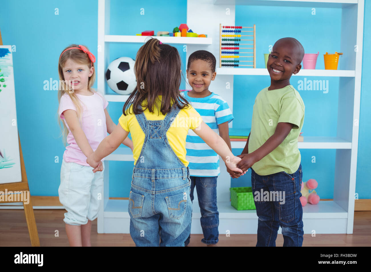 Happy kids holding hands together Stock Photo - Alamy