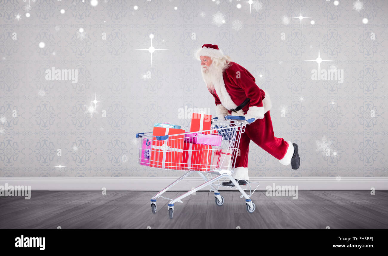 Composite image of santa pushing a shopping cart Stock Photo - Alamy