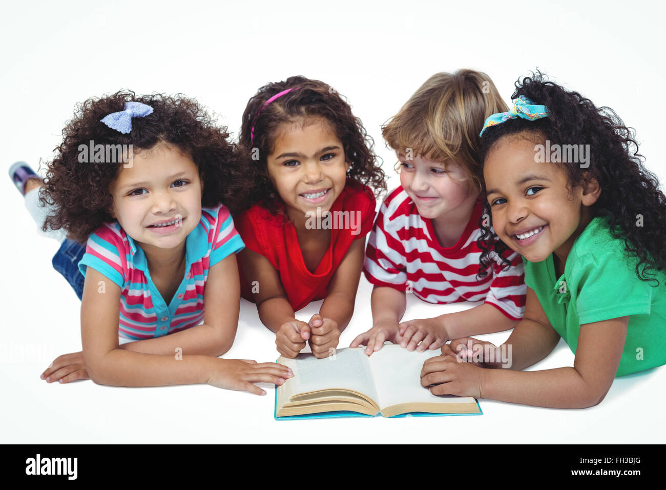 Four small kids reading a book together Stock Photo - Alamy