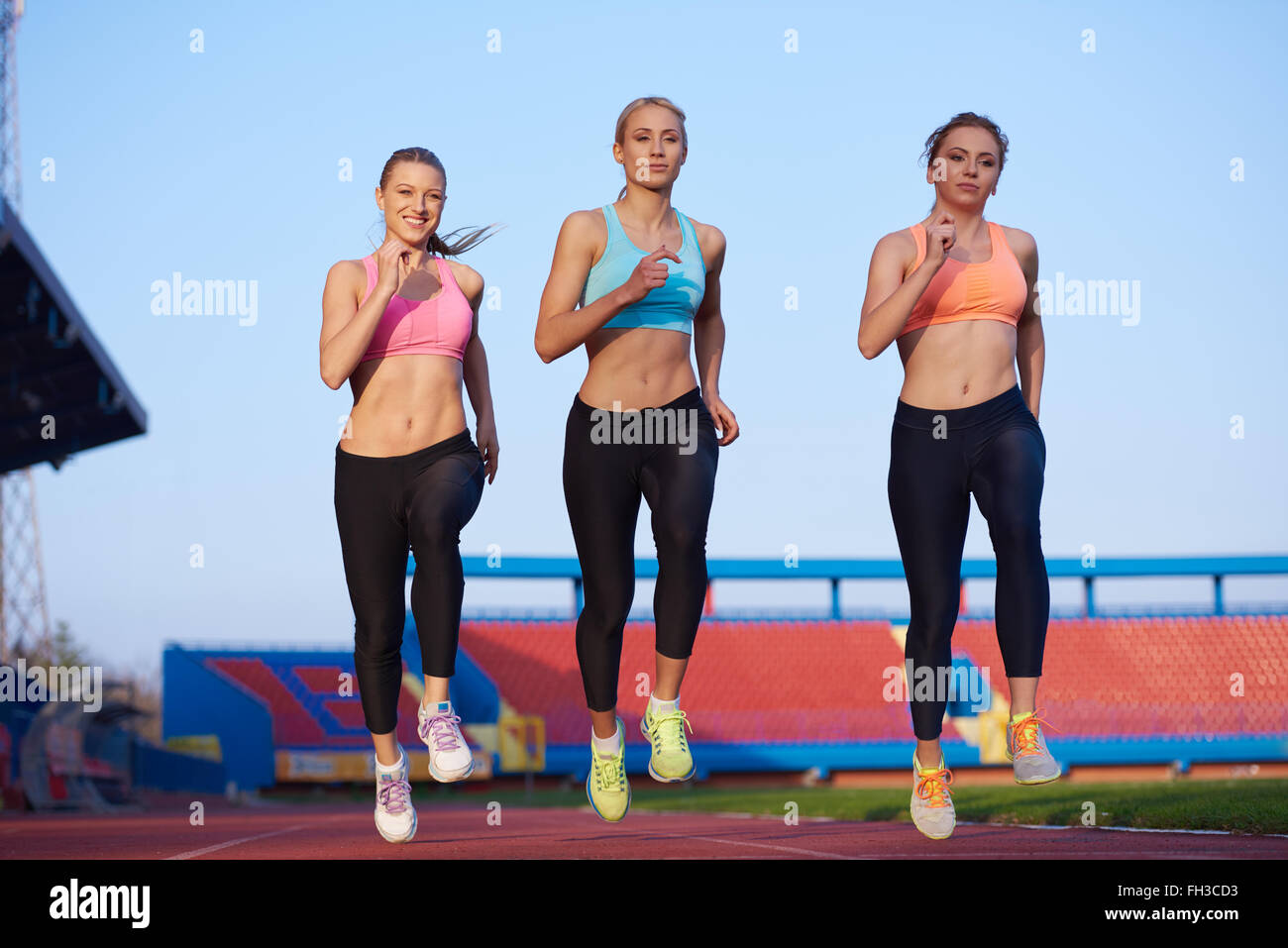 athlete woman group running on athletics race track Stock Photo - Alamy