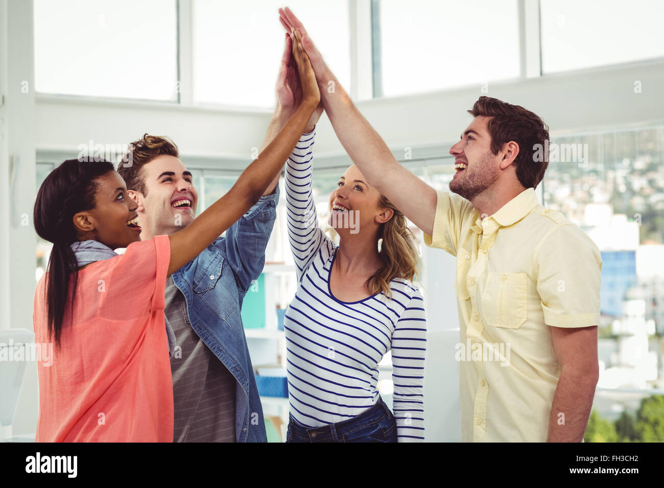 Happy creative team giving a motivational gesture Stock Photo - Alamy
