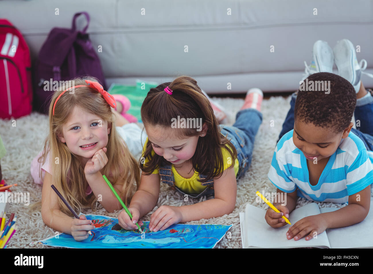 Smiling kids drawing pictures on paper Stock Photo - Alamy