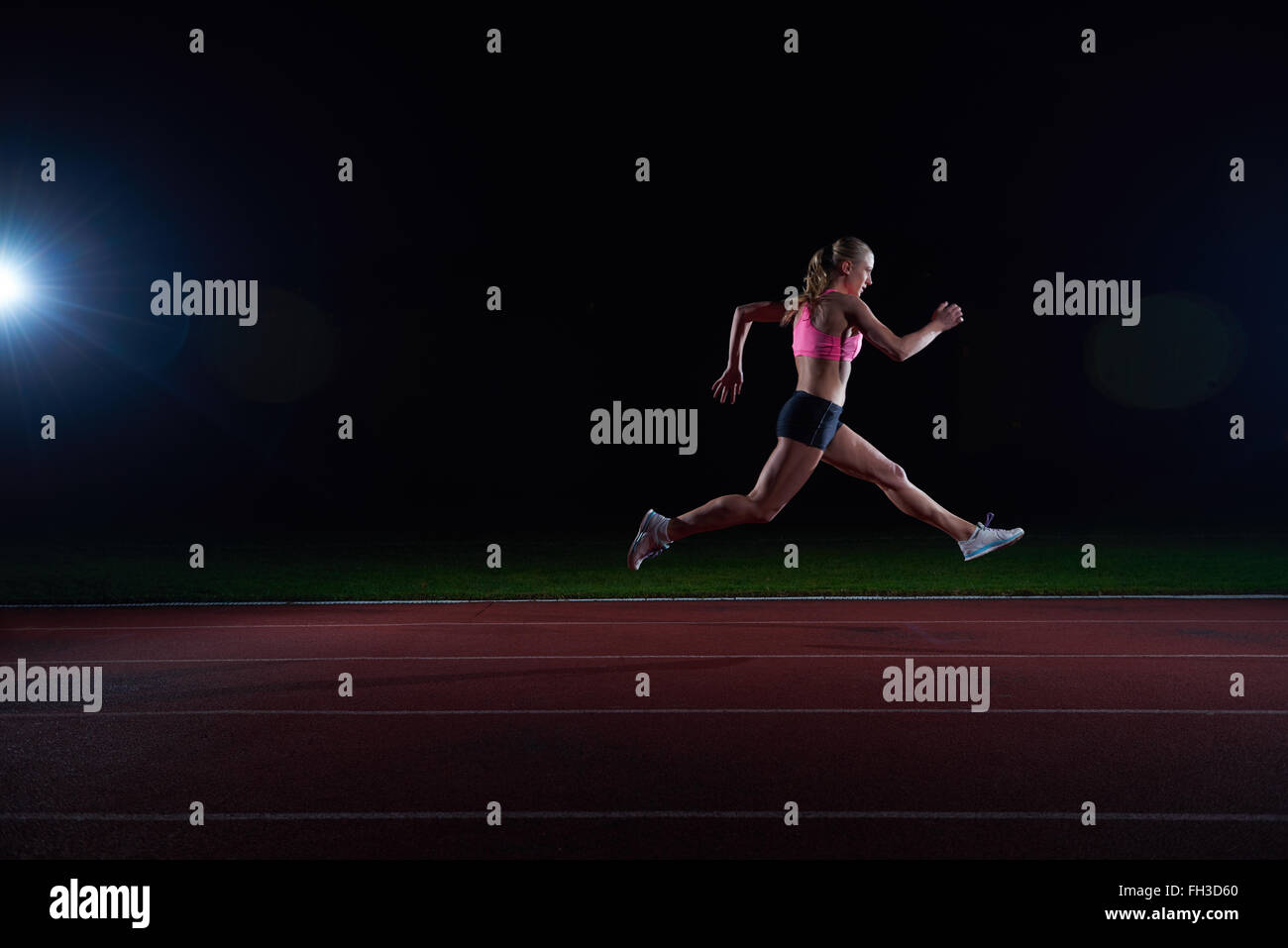 Athletic woman running on track Stock Photo - Alamy