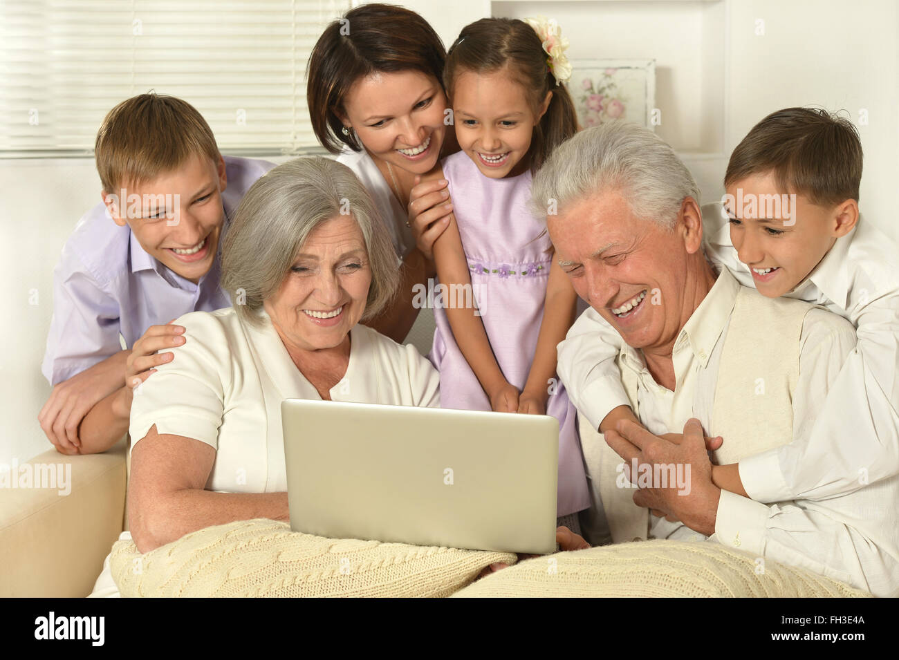 Happy family with kids with laptop Stock Photo - Alamy