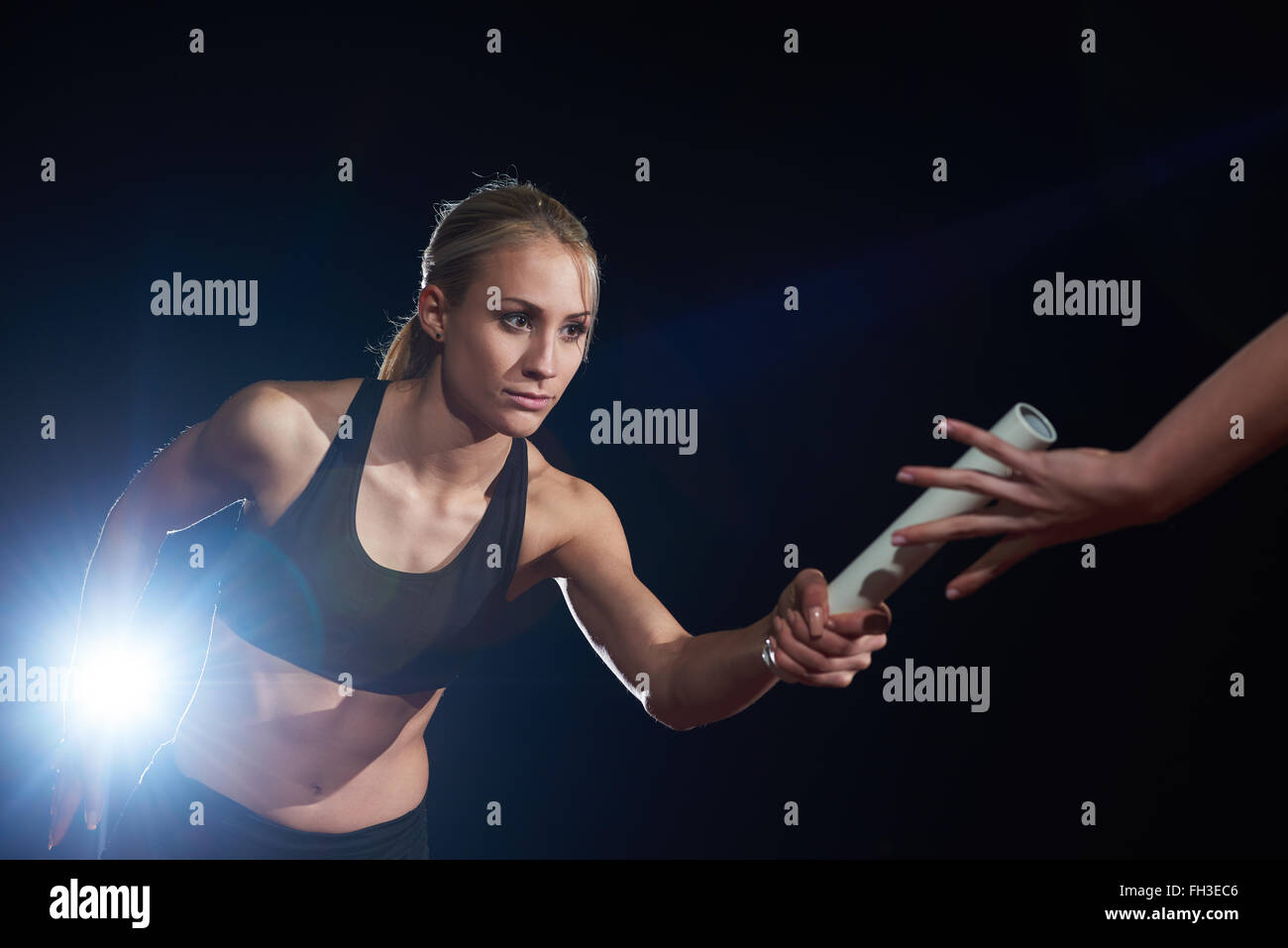 athletic runners passing baton in relay race Stock Photo - Alamy