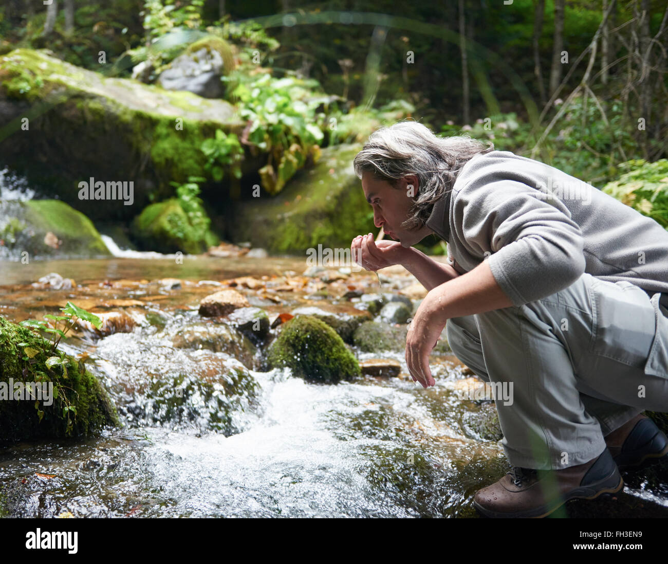 man drinking fresh water from spring Stock Photo - Alamy