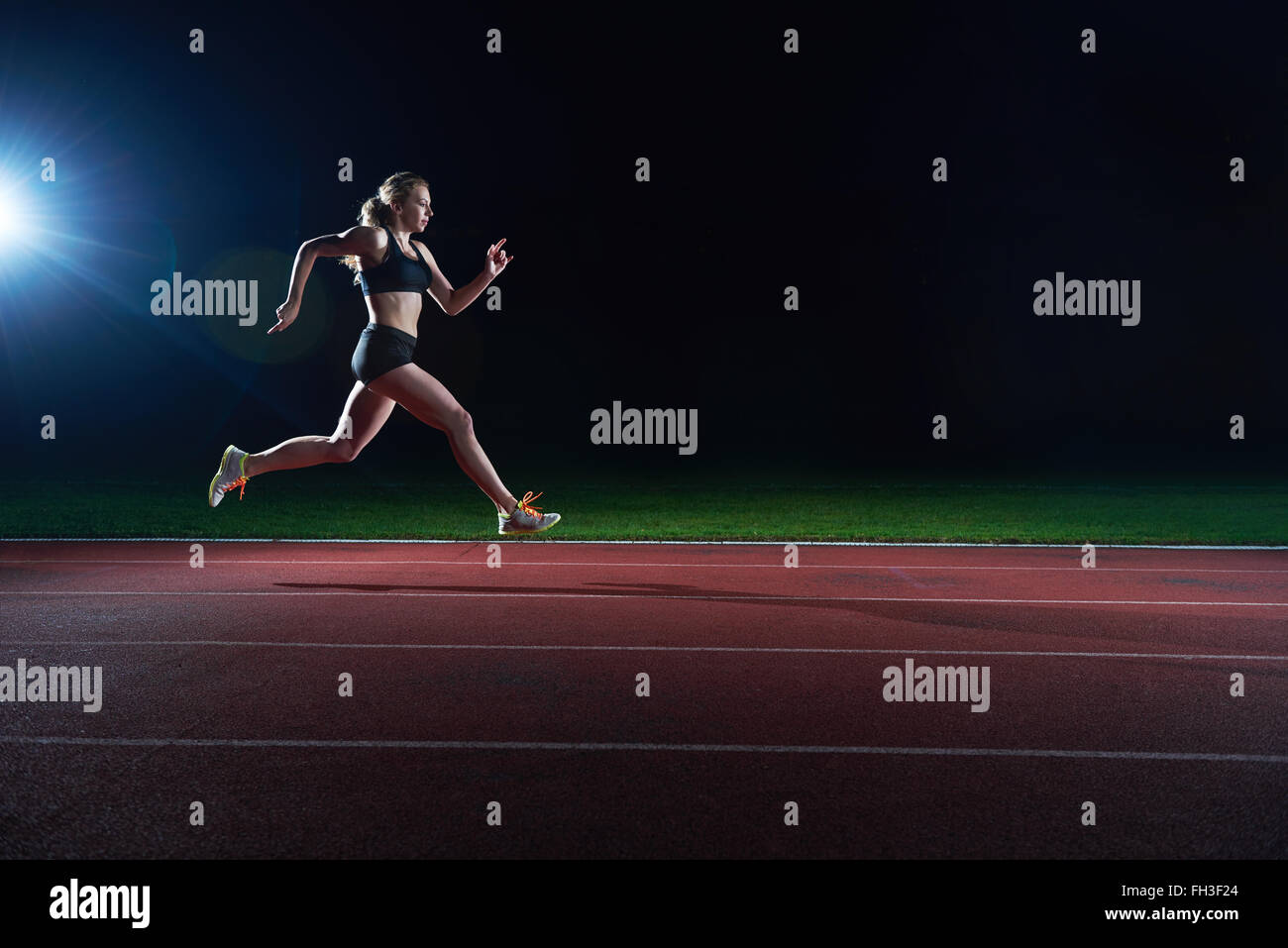 Athletic woman running on track Stock Photo - Alamy
