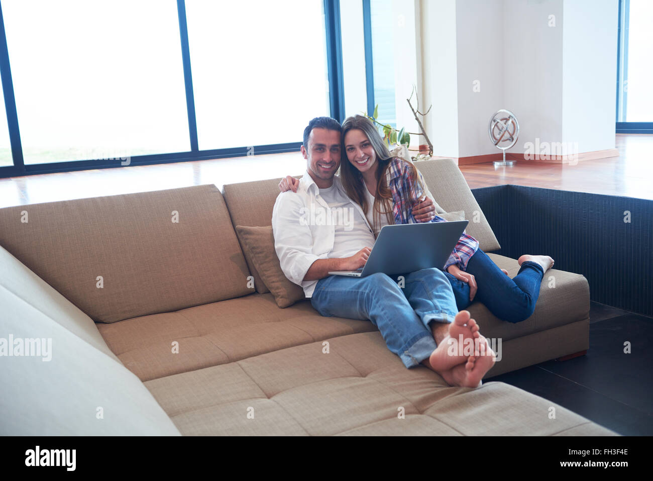 relaxed young couple working on laptop computer at home Stock Photo - Alamy