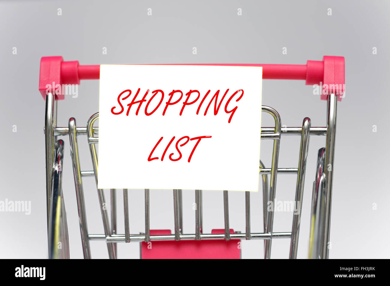 A miniature shopping trolley with shopping list sign on Stock Photo - Alamy