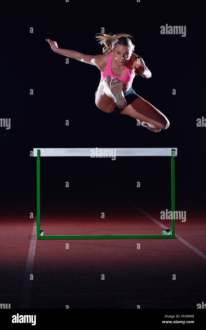 woman athlete jumping over a hurdles Stock Photo - Alamy