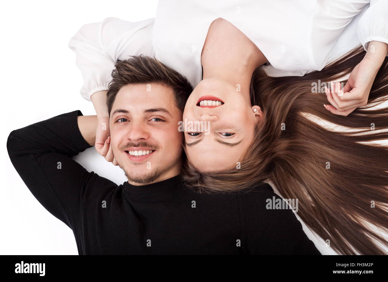 Happy young couple lying down on their back together Stock Photo - Alamy
