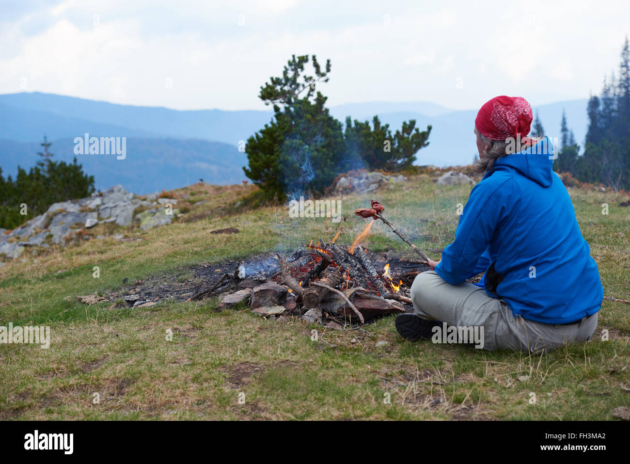 hiking man prepare tasty sausages on campfire Stock Photo - Alamy