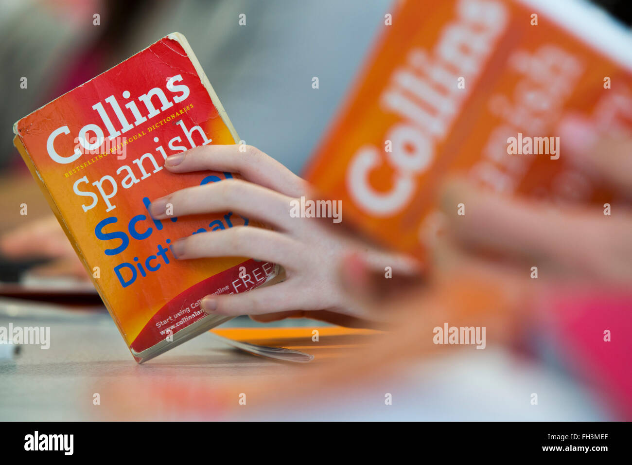 A Spanish language lesson in a school and hands holding well worn ...