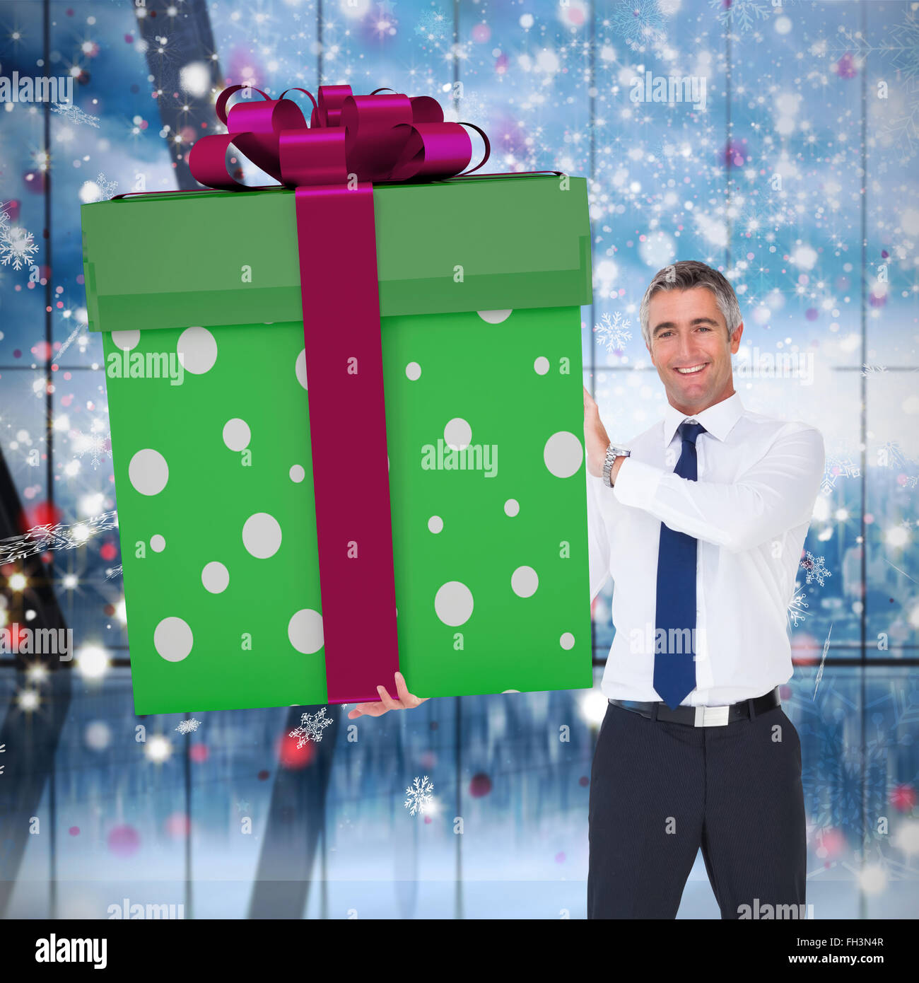 Composite image of stylish man with giant gift Stock Photo - Alamy