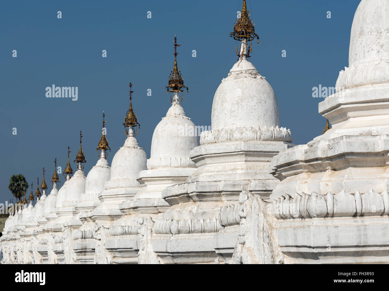 Row of whitewashed kyauksa gu stupas at Kuthodaw Pagoda in Mandalay ...