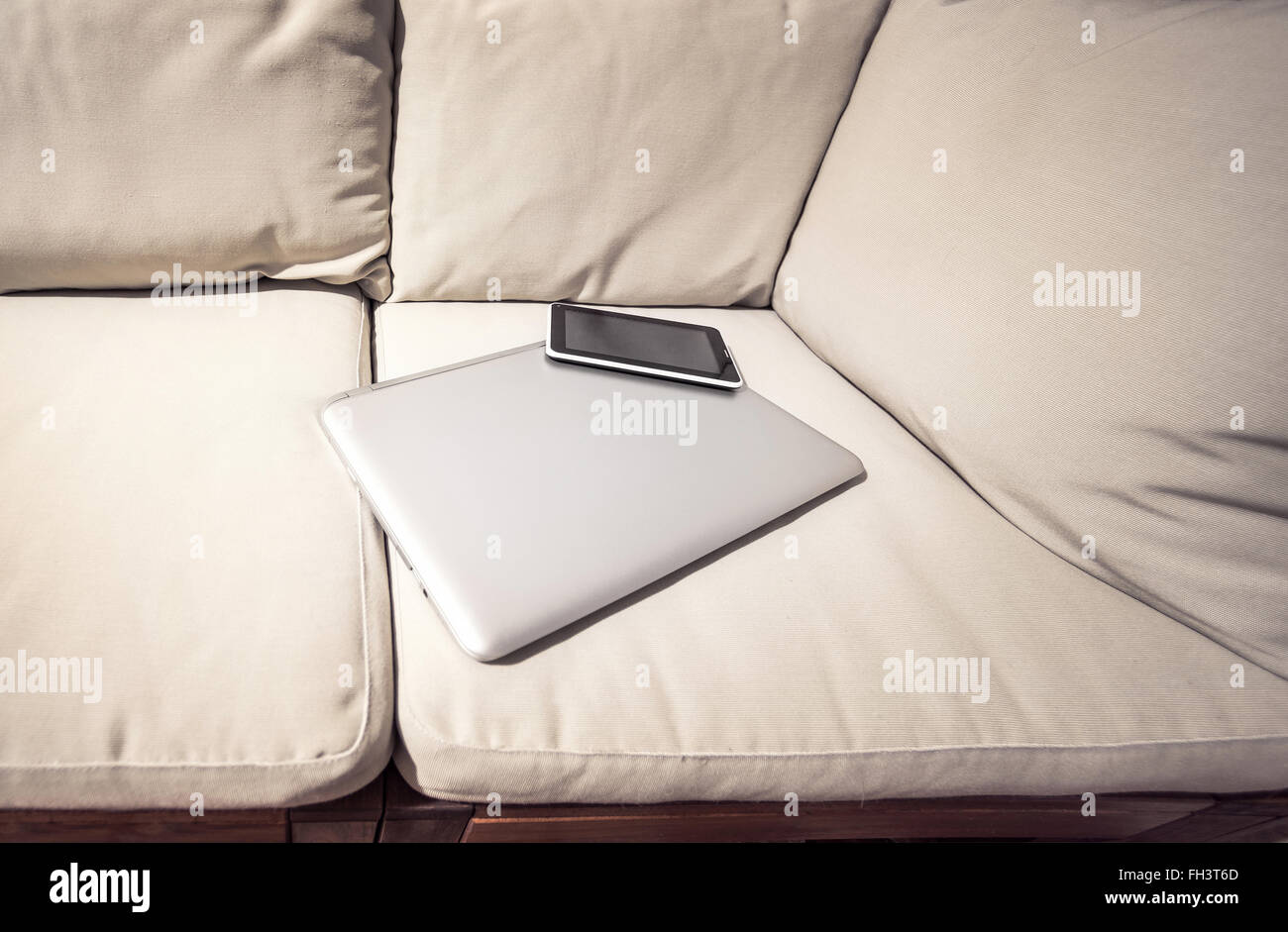 gadgets on the couch Stock Photo - Alamy