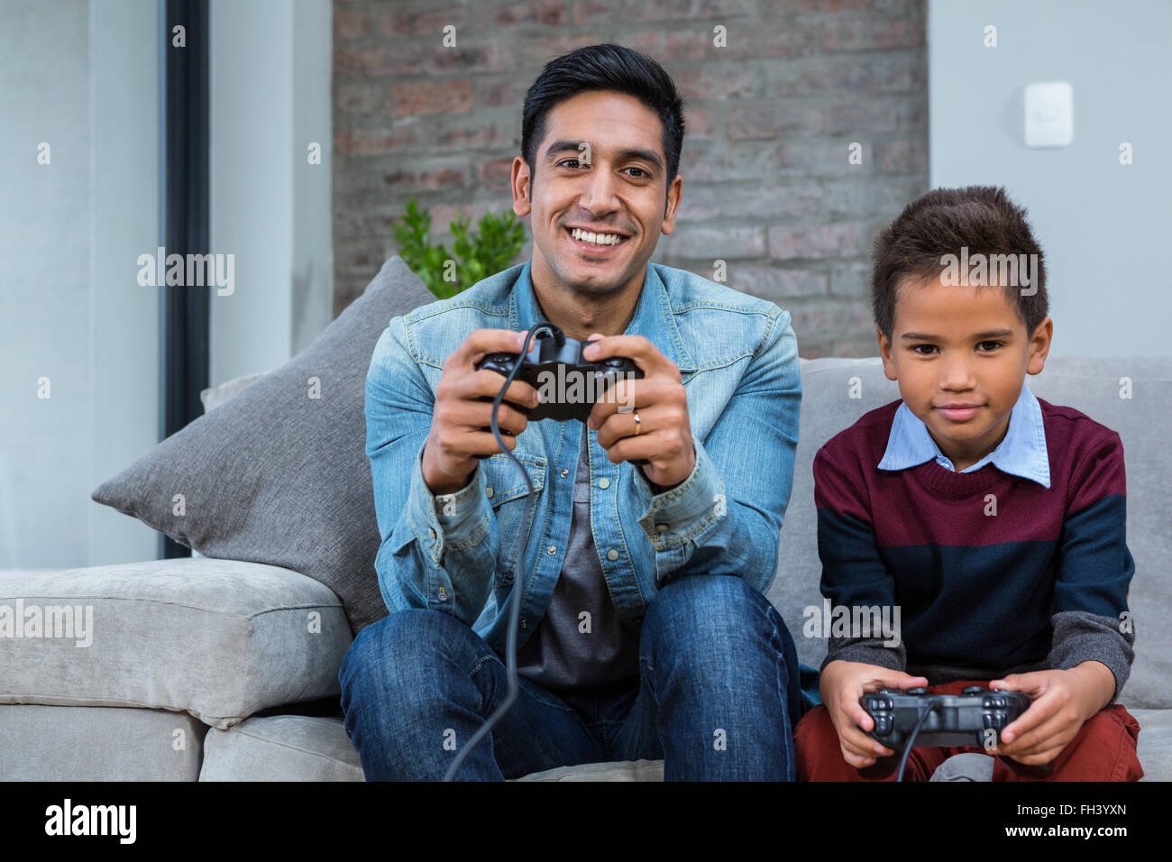 Happy father playing video games with his son Stock Photo - Alamy