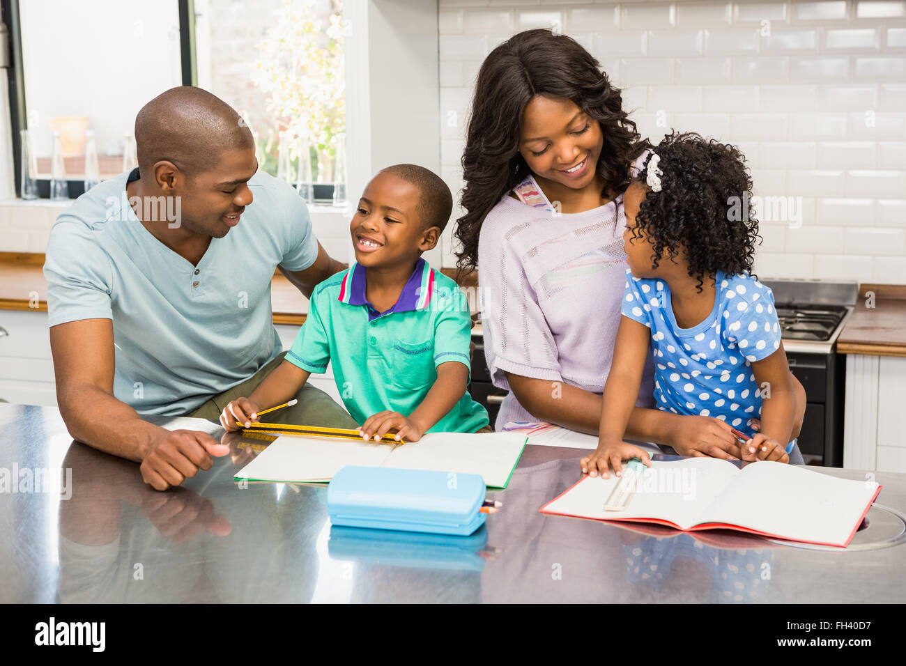 Parents helping children doing homework Stock Photo - Alamy